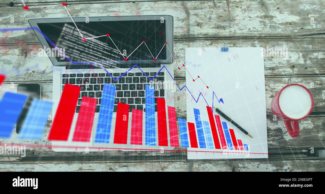 Image of multiple graphs, coffee cup and computer language, overhead view of laptop and notepad ...