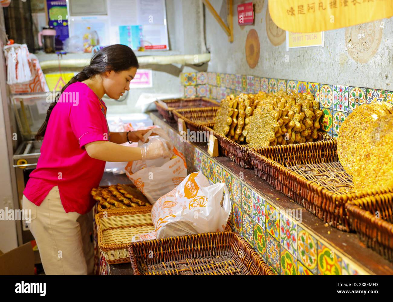 URUMQI, CHINA - MAY 24, 2024 - A vendor packs naan bread for tourists ...