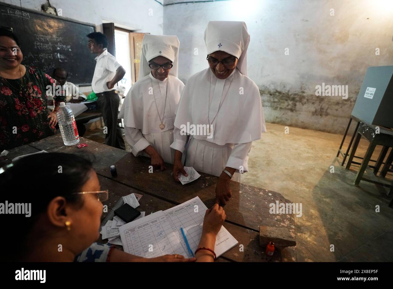 A polling official marks the index finger of a Christian nun with an ...