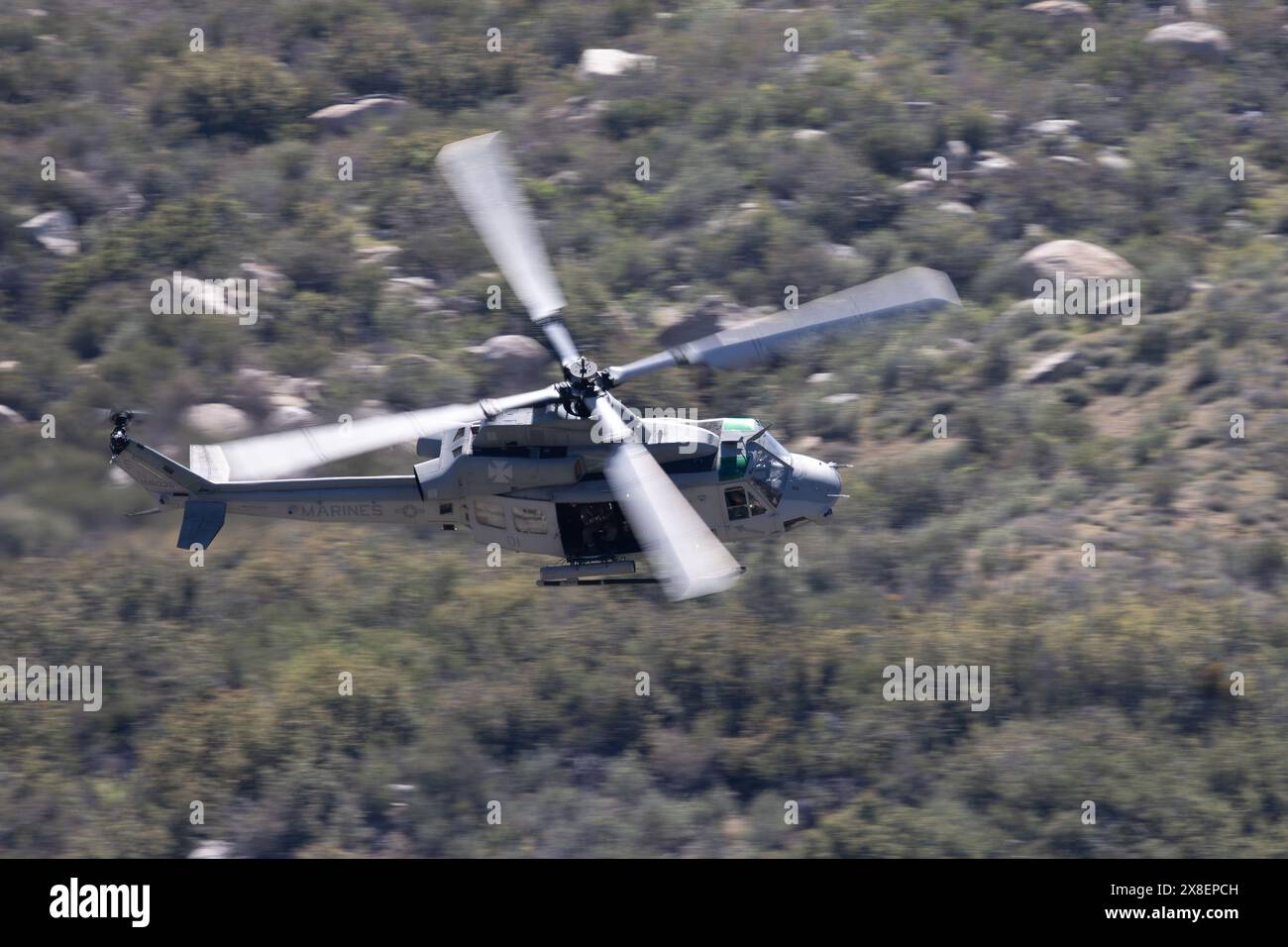 A United States Marines UH-1Y Venom helicopter flies through the ...
