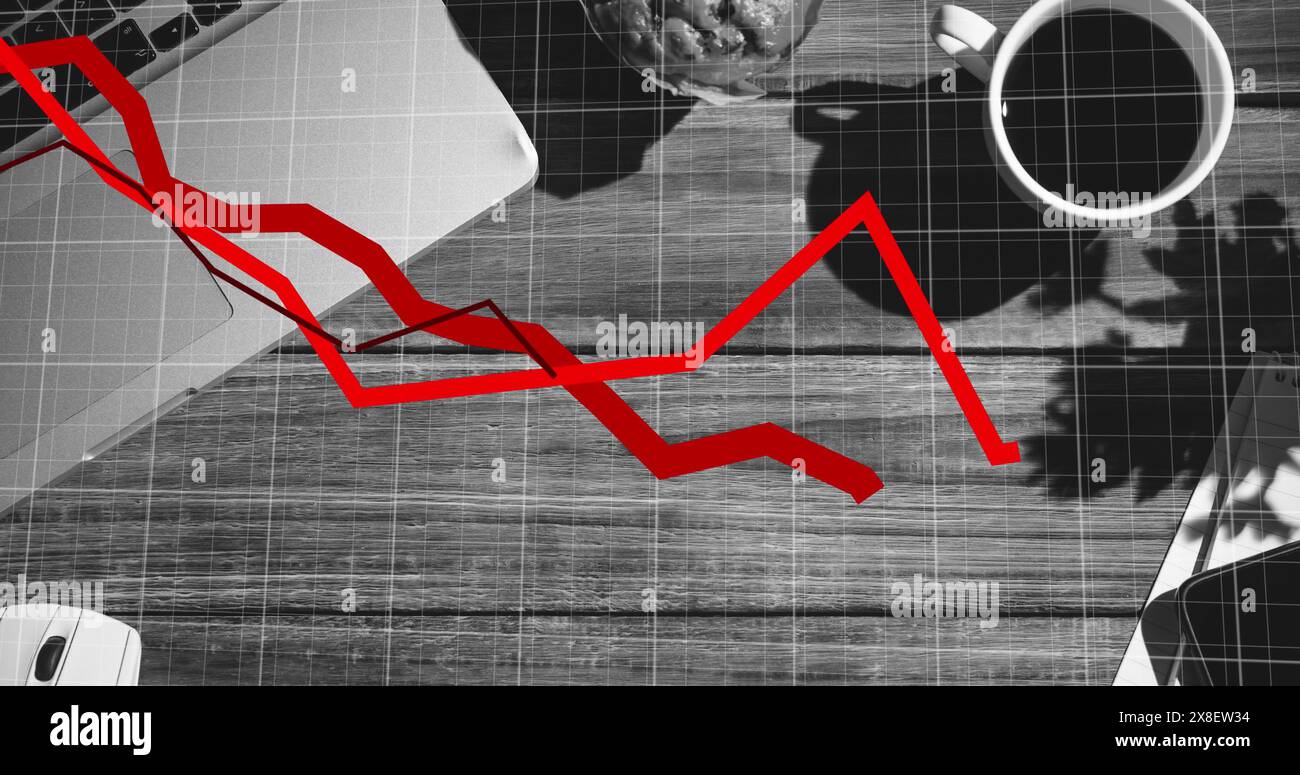 Red line graph displaying decline, covering a desk with a laptop and ...