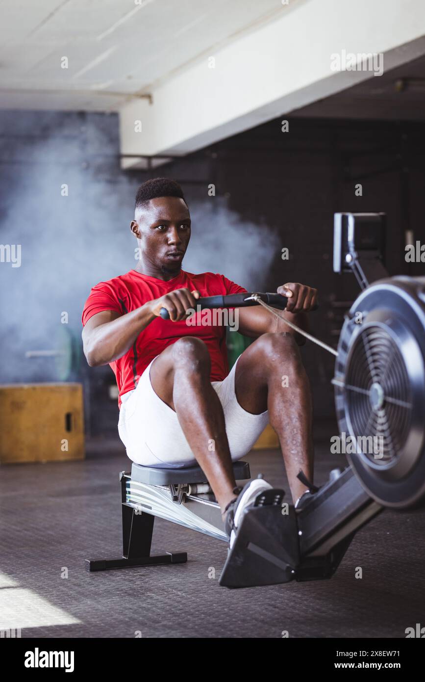 At gym, African American man trains on rowing machine looking focused ...