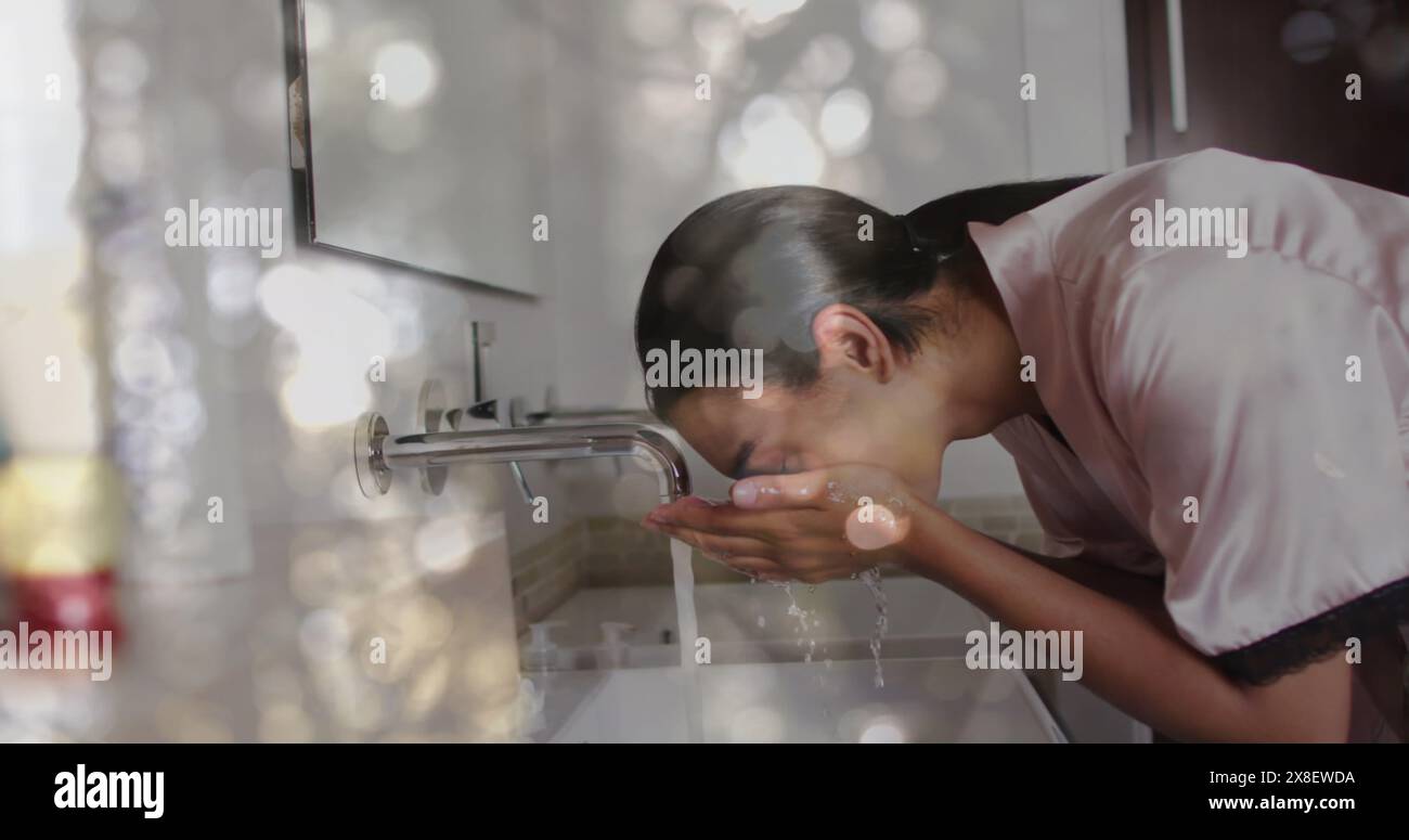 Image of glowing lights over biracial woman washing face Stock Photo ...