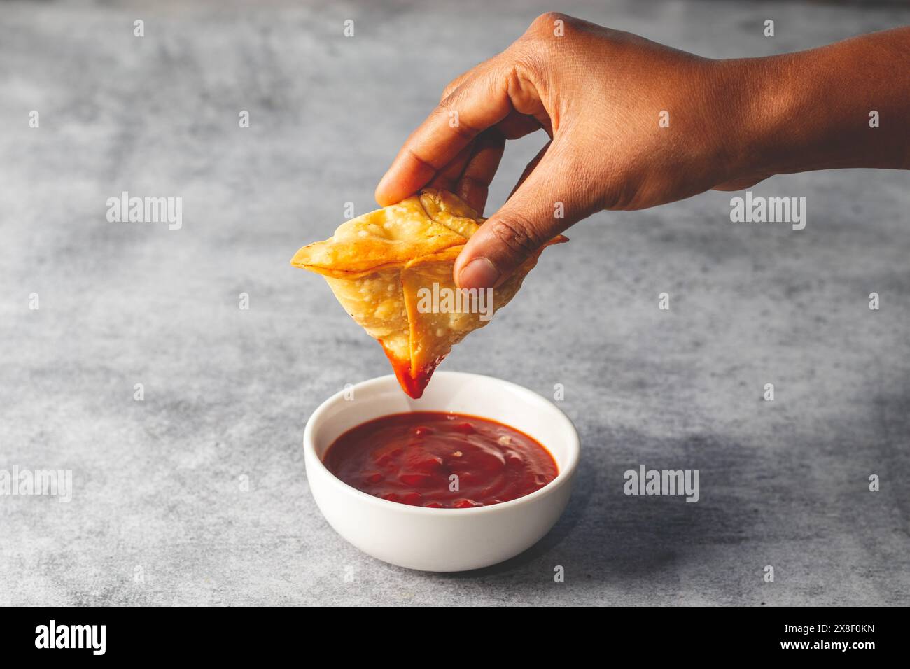 a lady dipping Samosa on tomato sauce. Indian street food Stock Photo ...