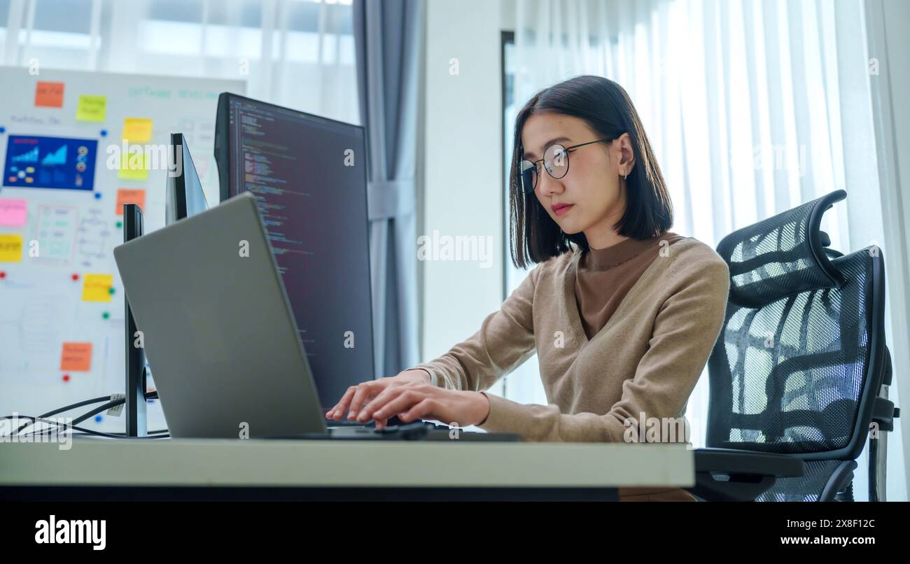 Asian Prompt Engineer Develop Coding App With Software Data Sitting In Front Of Computer Monitor