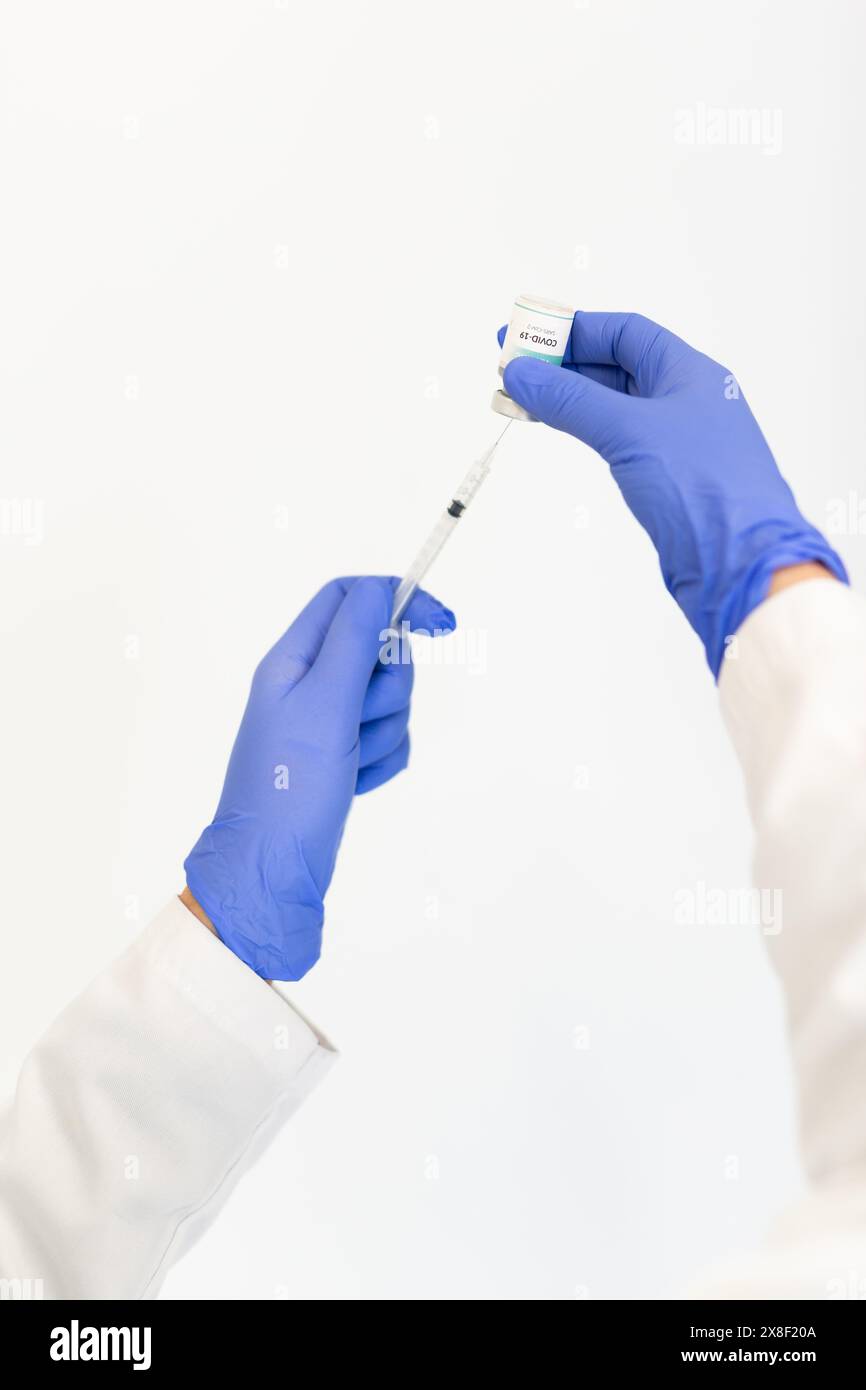 A healthcare professional is drawing a dose of the COVID-19 vaccine ...