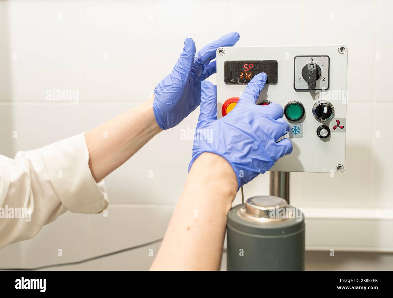 Hands in blue gloves in production, set the mode of operation of the ...