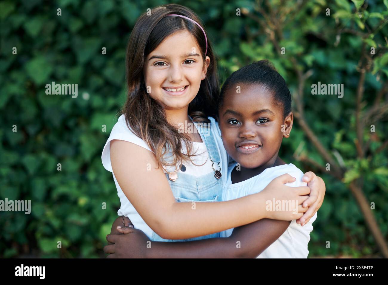 Children, diversity and hug with girl friends outdoor in garden ...
