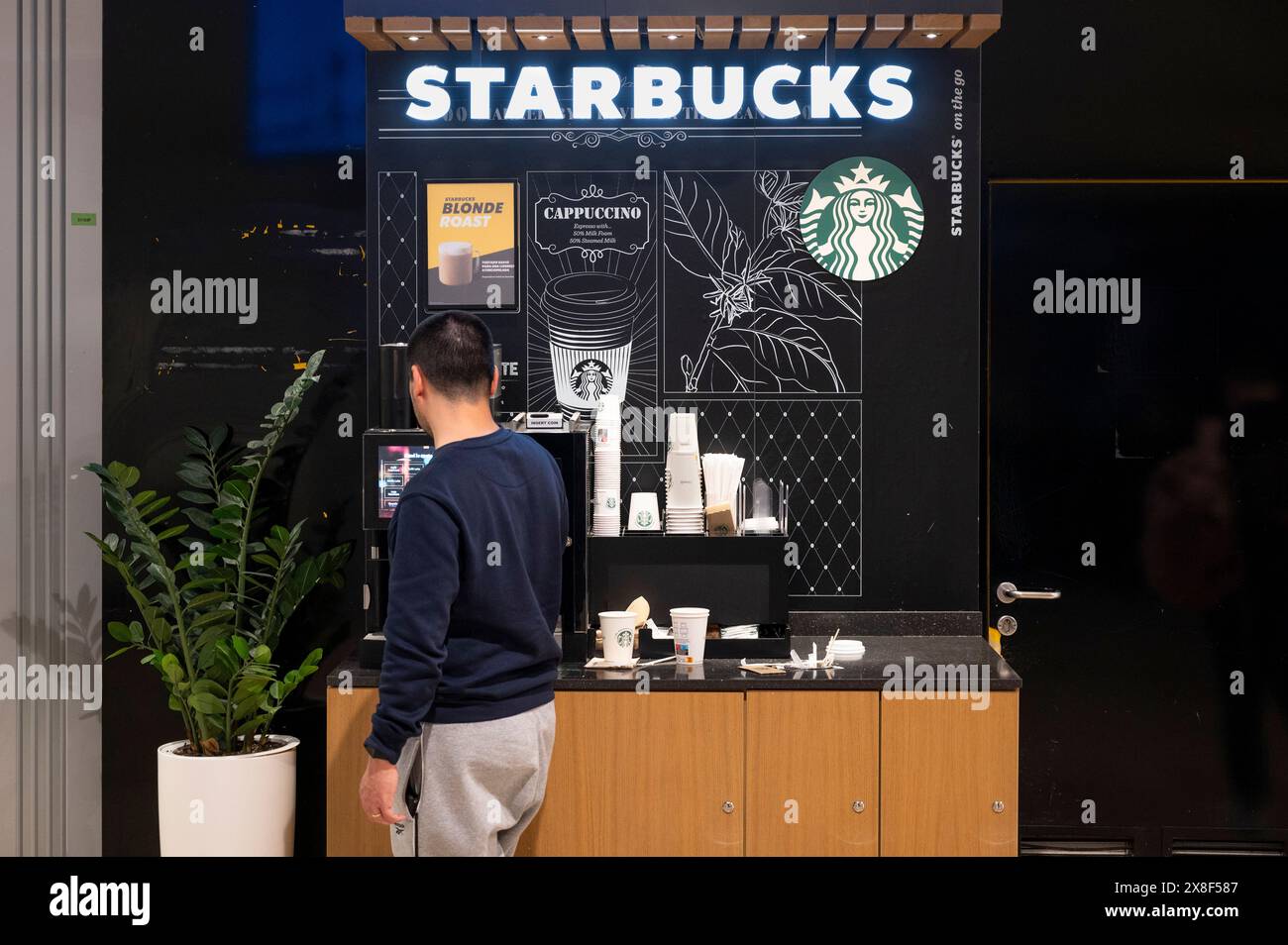Madrid, Spain. 26th Apr, 2024. A traveler orders a coffee from an ...
