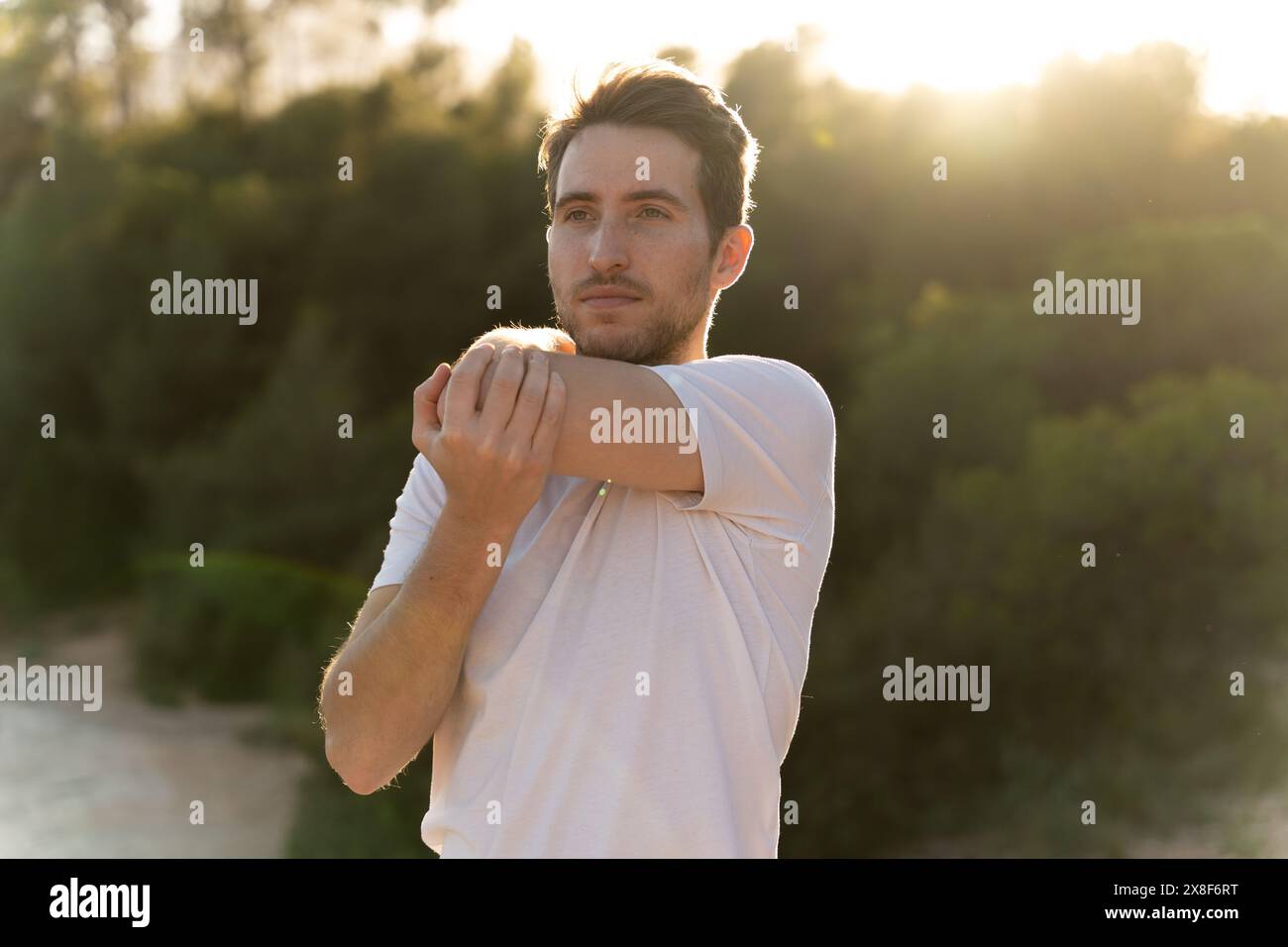 Portrait of a man smiling doing exercises in nature. A man stretching ...