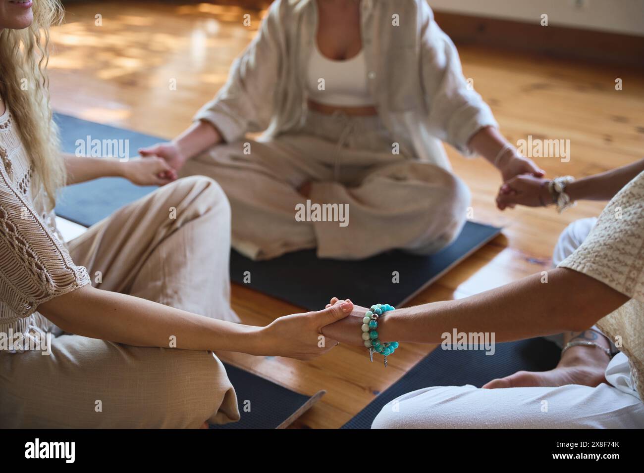 Three diverse women group sitting in circle meditating doing yoga ...