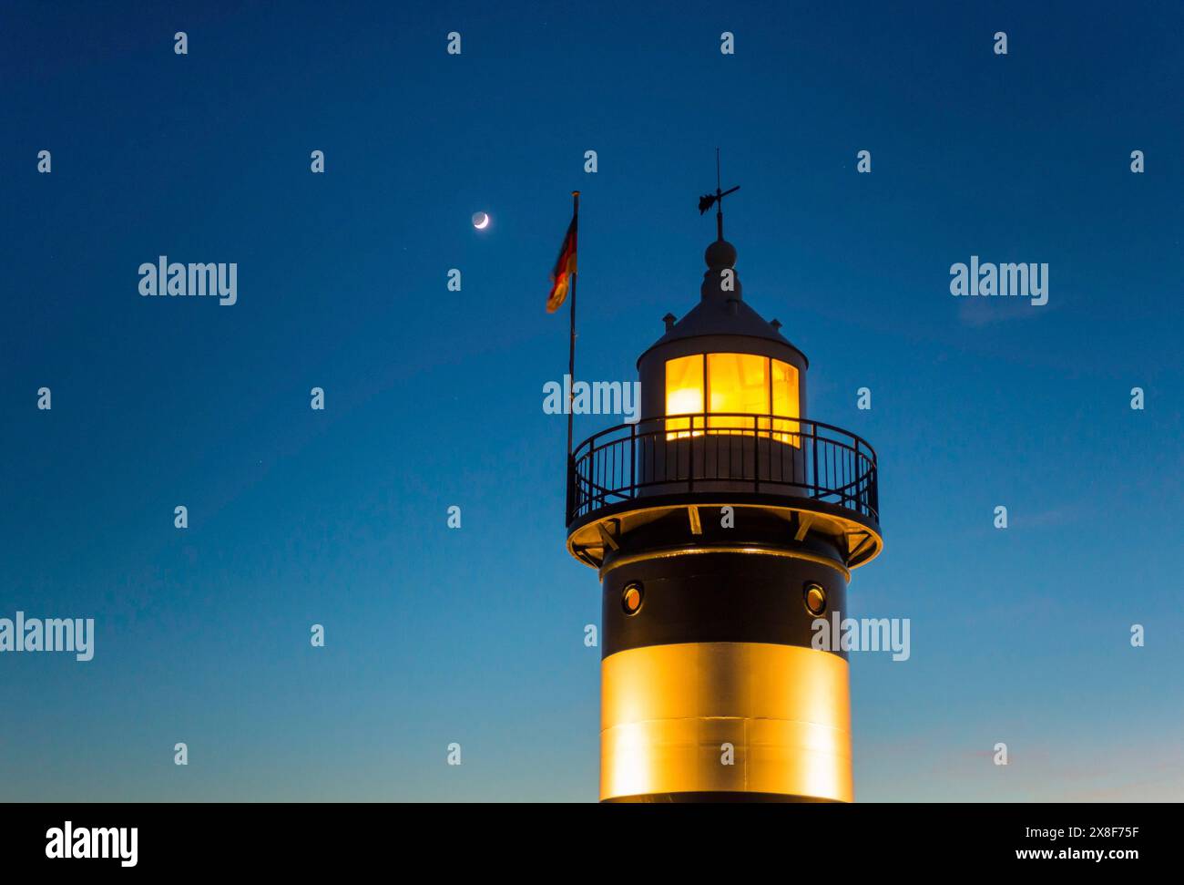 Upper segment of an illuminated lighthouse at night, black and white ...