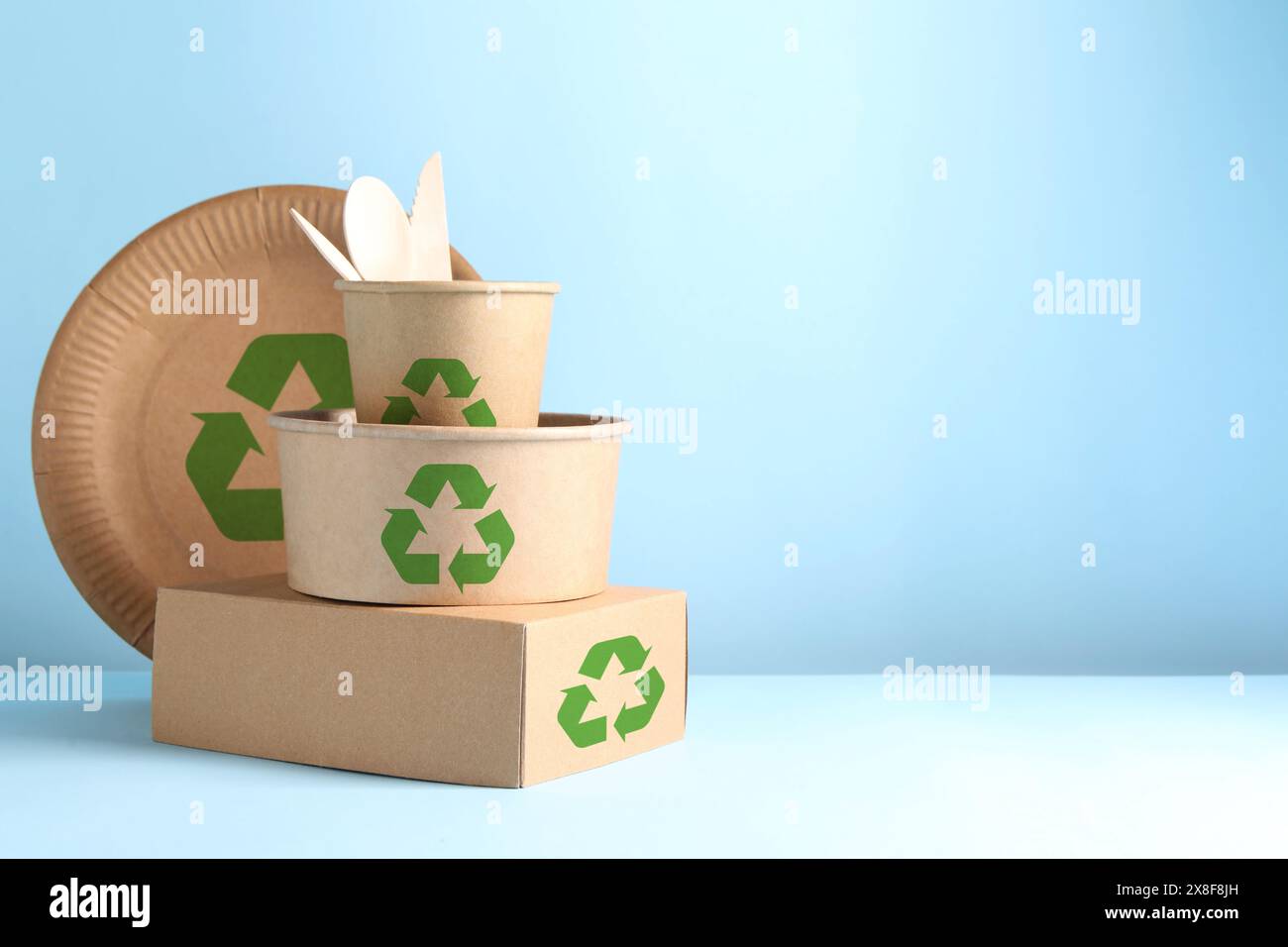 Set of eco friendly food packaging with recycling symbols on light blue ...