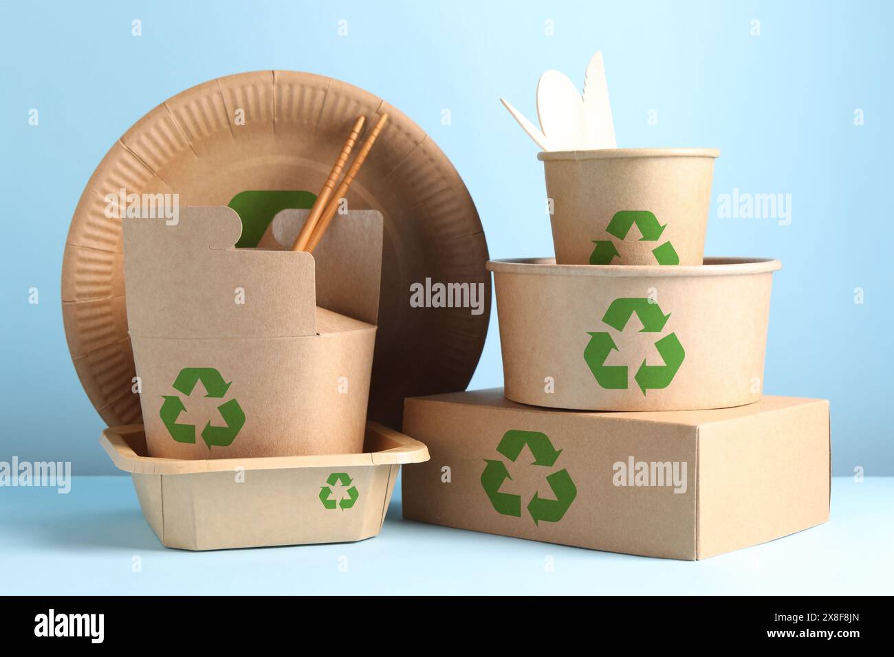 Set of eco friendly food packaging with recycling symbols on light blue ...