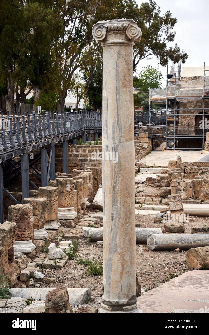 a single stone column standing among the ruins of ancient buildings in ...