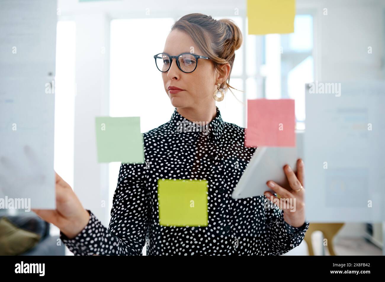 Glass wall, business woman and sticky note with tablet for planning ...