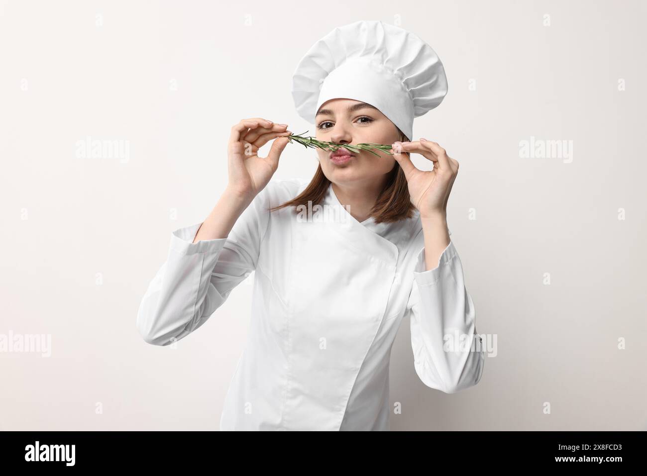 Professional chef with rosemary having fun on light background Stock ...