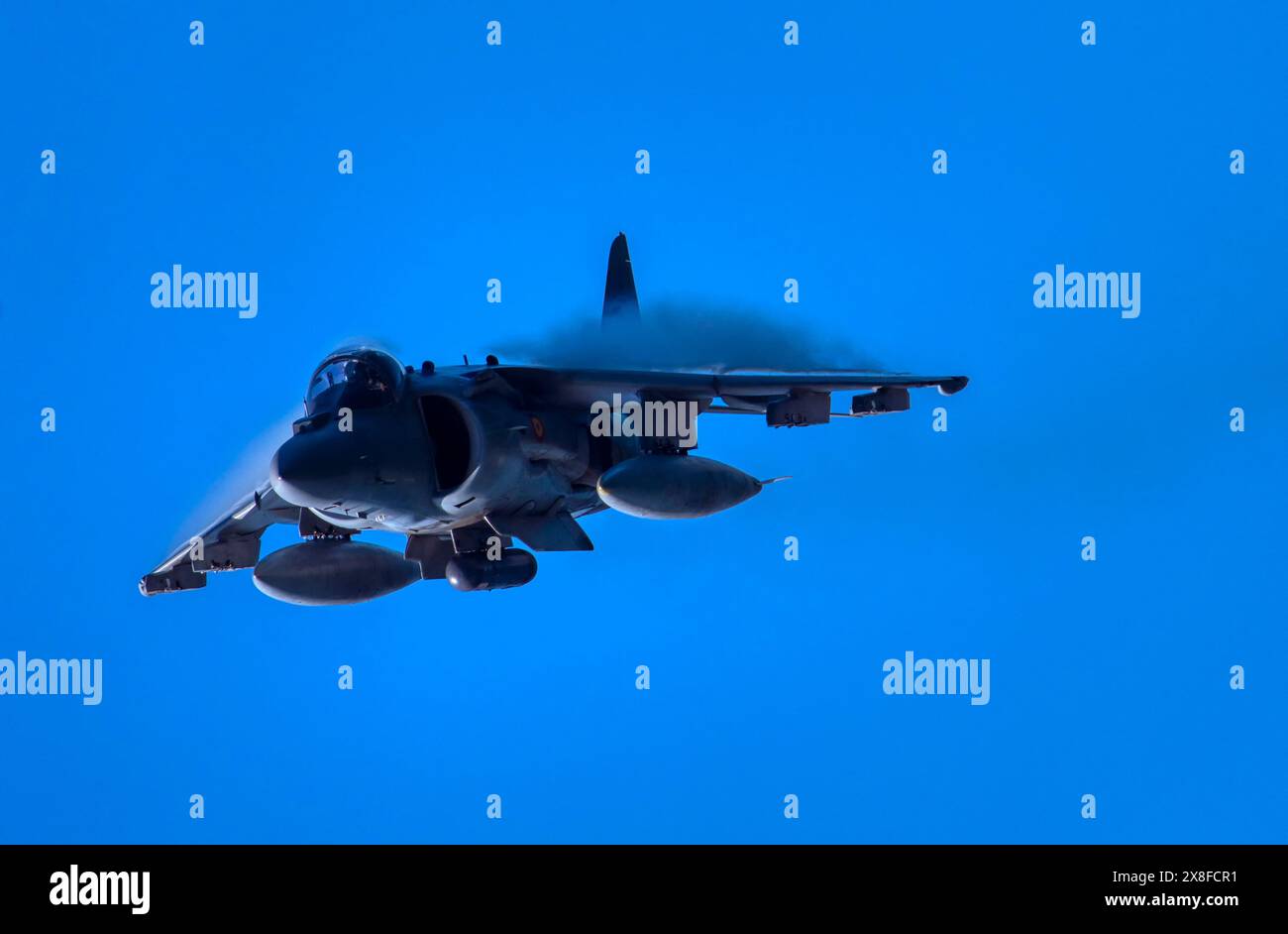 An AV-8B Harrier fighter jet of the Spanish Navy flying over the bay of ...