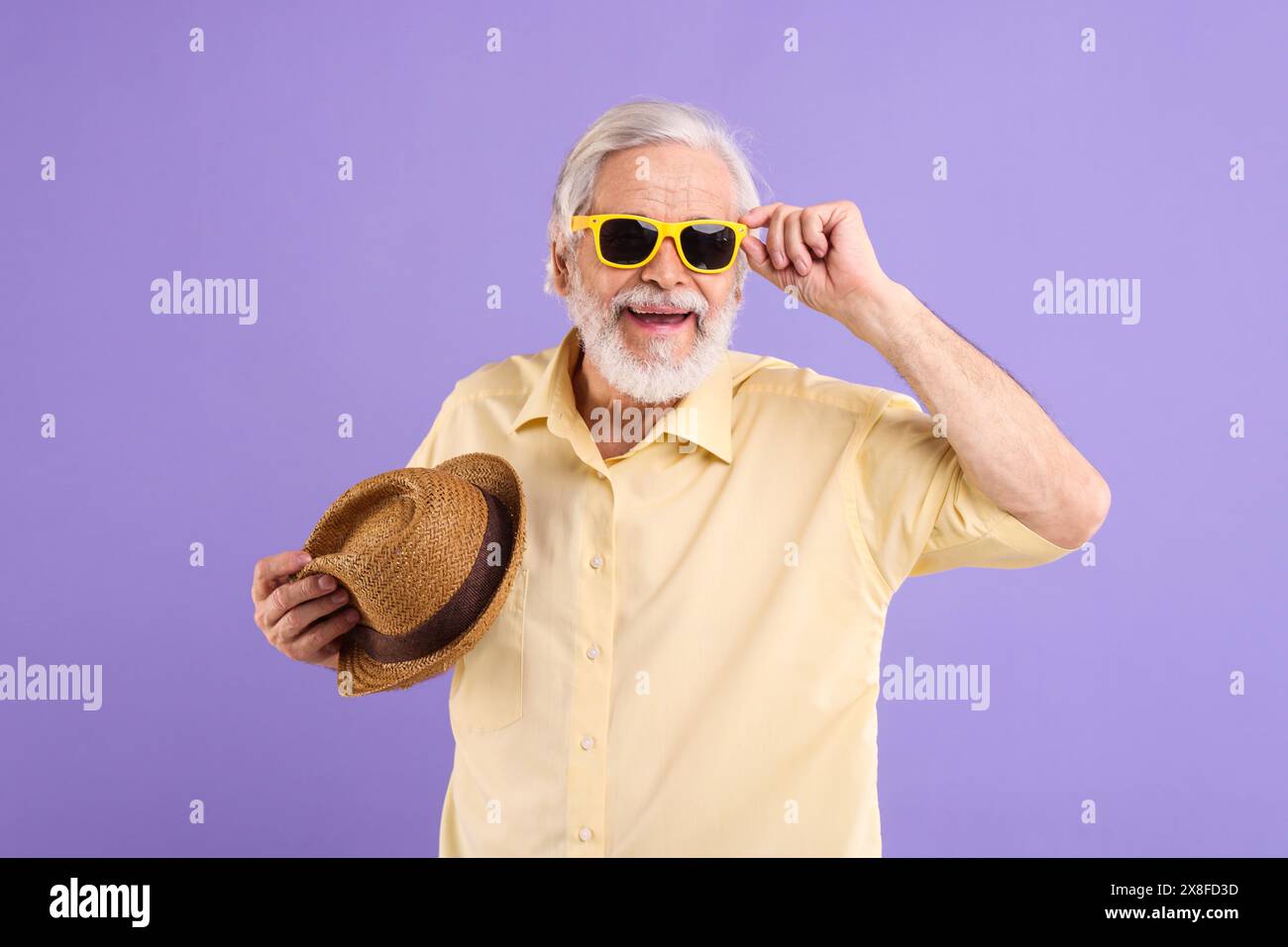 Portrait of stylish grandpa with sunglasses and hat on purple ...