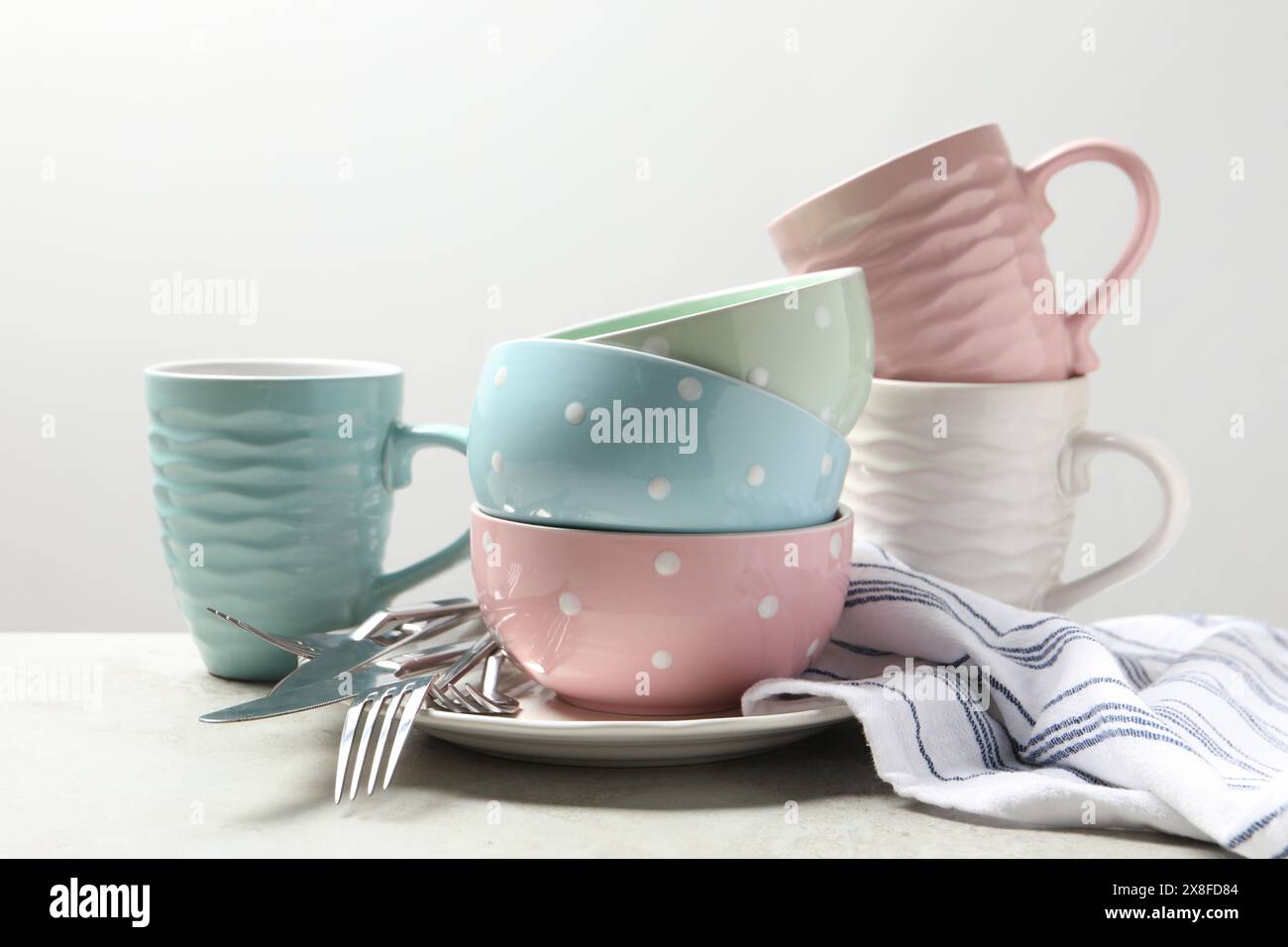 Beautiful ceramic dishware, cups and cutlery on light grey table Stock ...