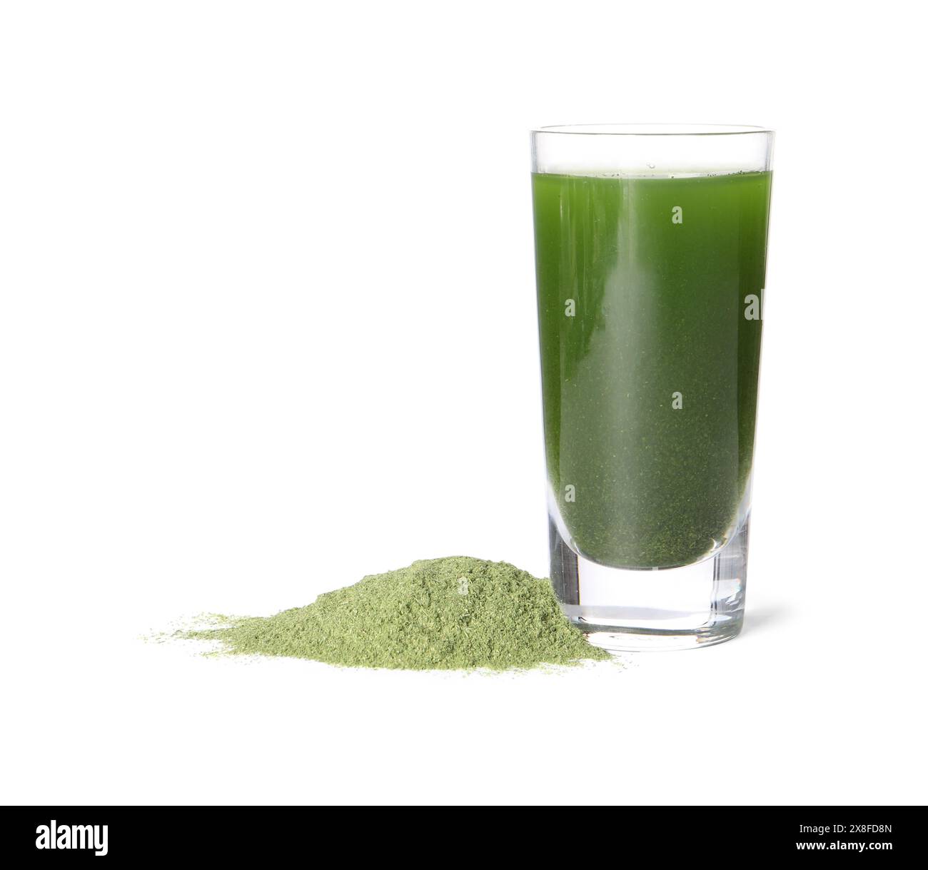 Wheat grass drink in shot glass and pile of green powder isolated on ...