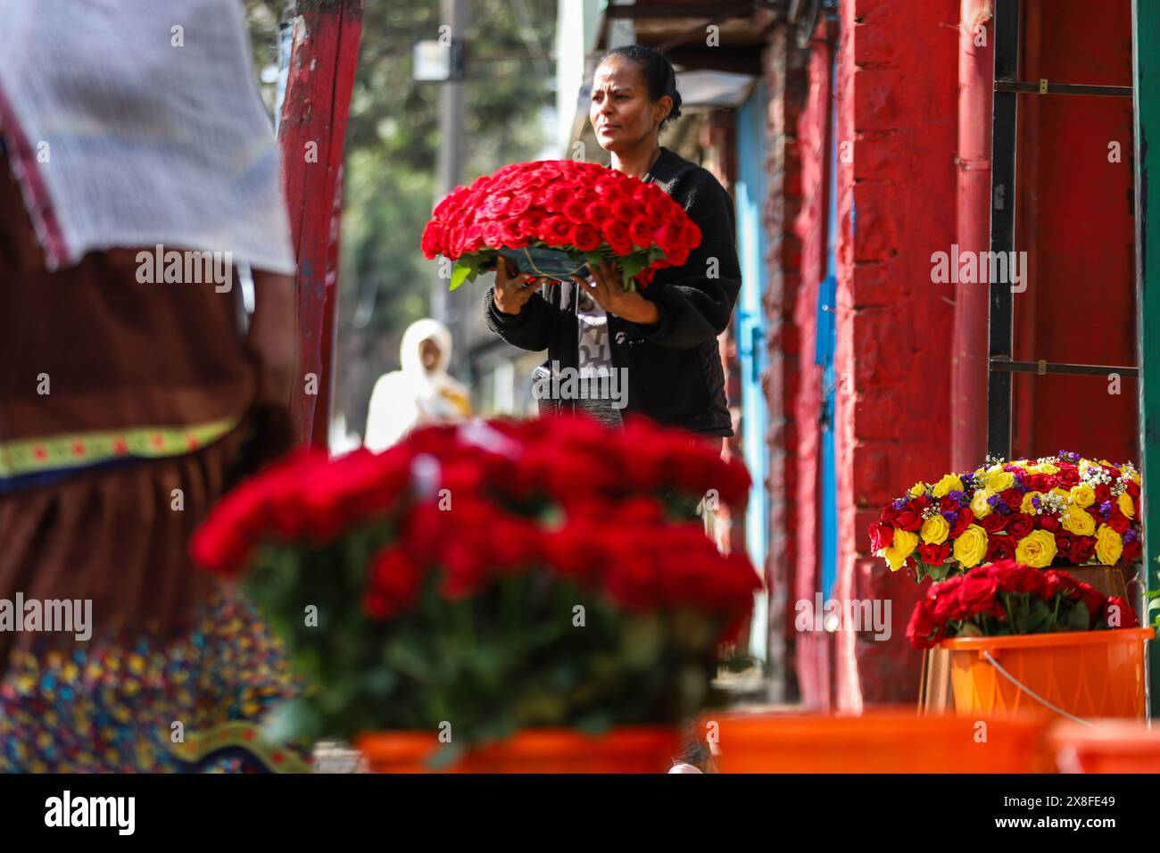 Addis Ababa, Ethiopia. 24th May, 2024. A woman holds a bunch of flowers ...