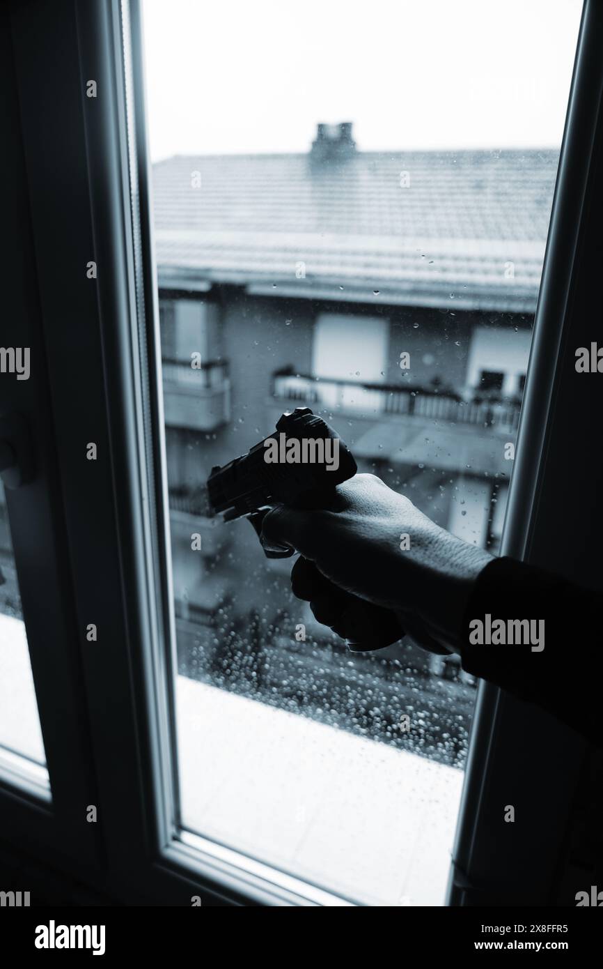 Gunman holding pistole in window dramatic photo book cover design Stock ...