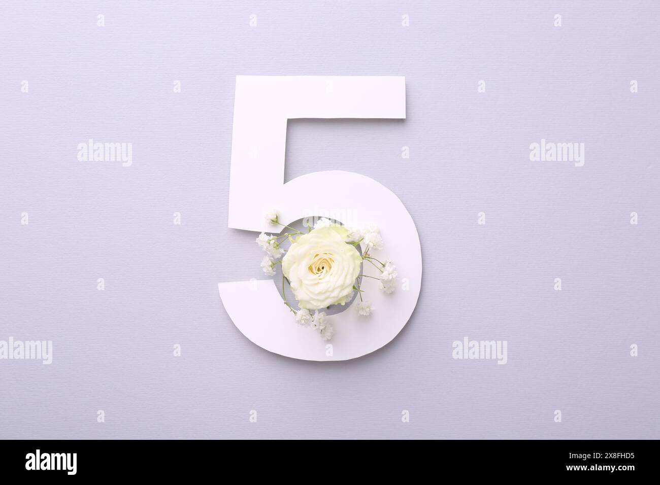 Paper number 5 and beautiful flowers on light grey background, top view ...