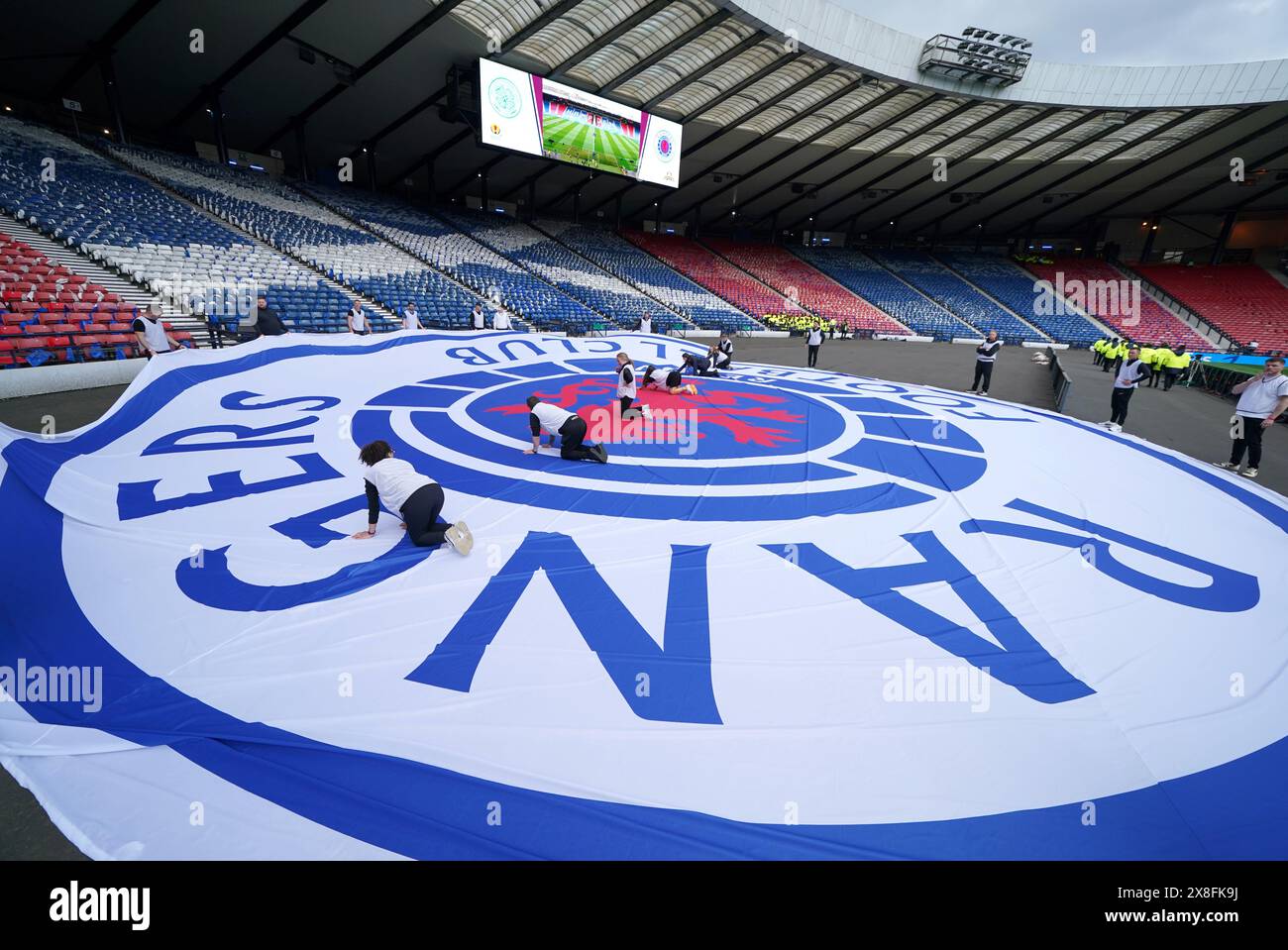 Stewards lay a Rangers banner on the pitch ahead of the Scottish Gas ...