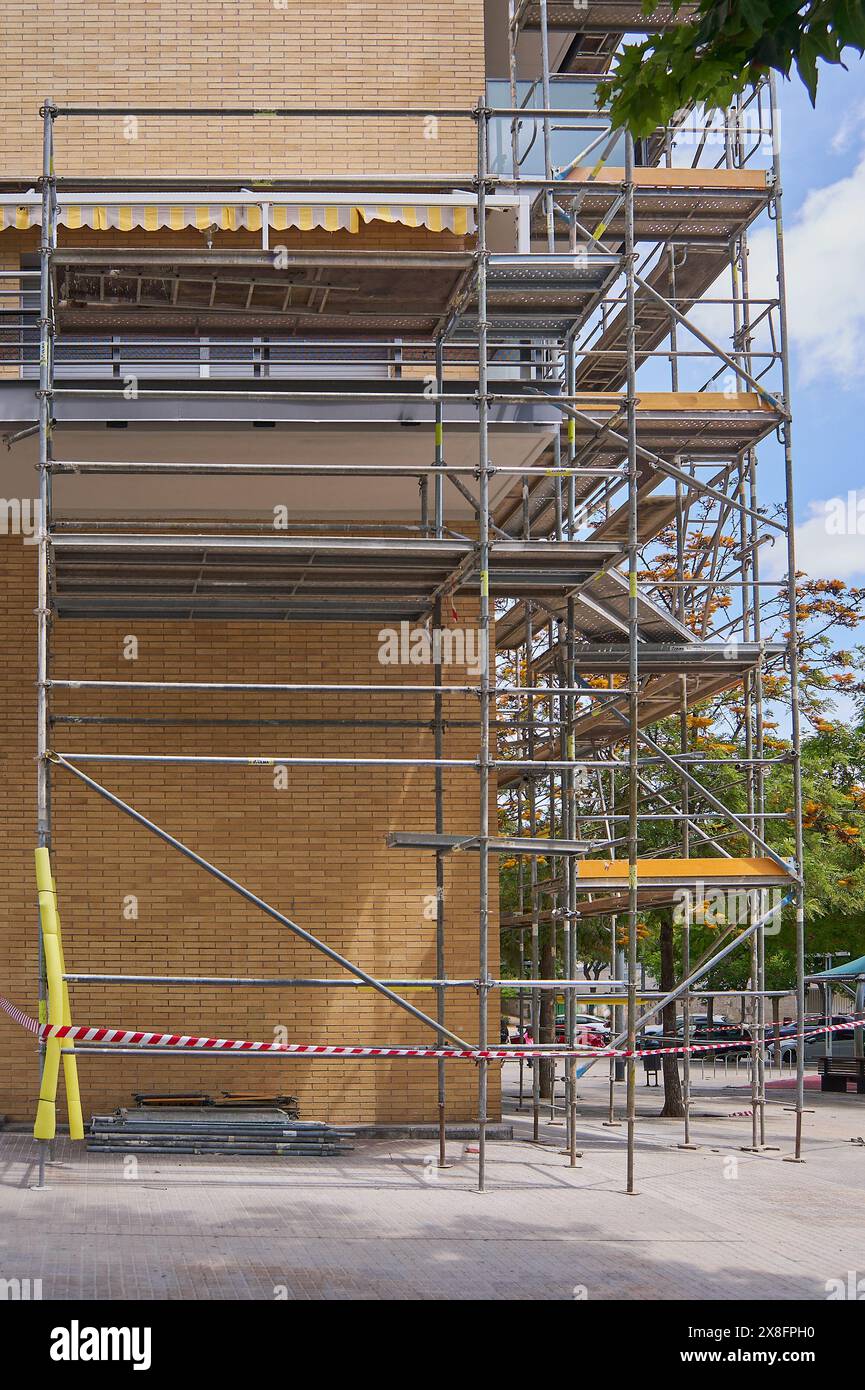 Multi-level metal scaffolds against building with yellow insulation ...