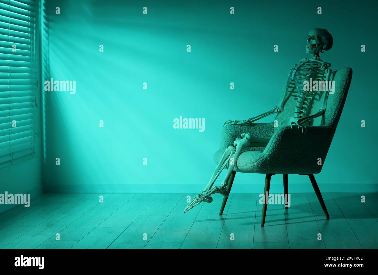 Waiting concept. Human skeleton sitting in armchair indoors, space for ...