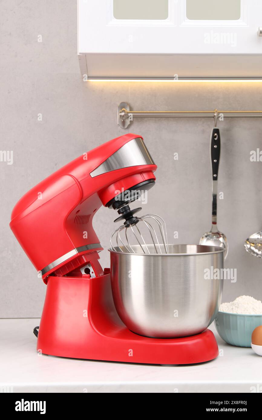 Modern red stand mixer on white table in kitchen Stock Photo - Alamy
