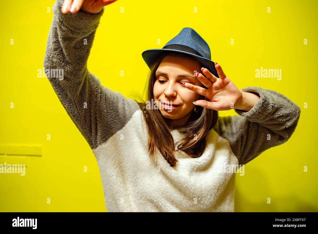 Woman in Cozy Sweater Dancing Against Bright Yellow Wall During Daytime ...