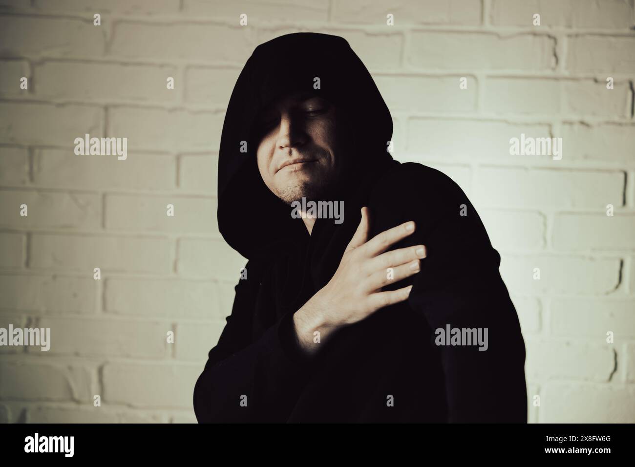 A man wearing a black hoodie is energetically dancing with expressive ...
