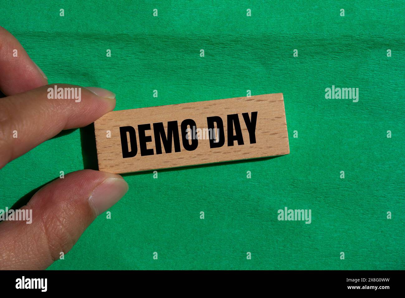 Demo day words written on wooden block with green background ...