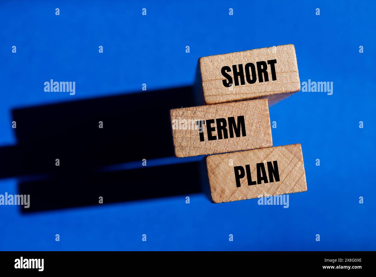 Short term plan words written on wooden blocks with blue background. Conceptual short term plan ...
