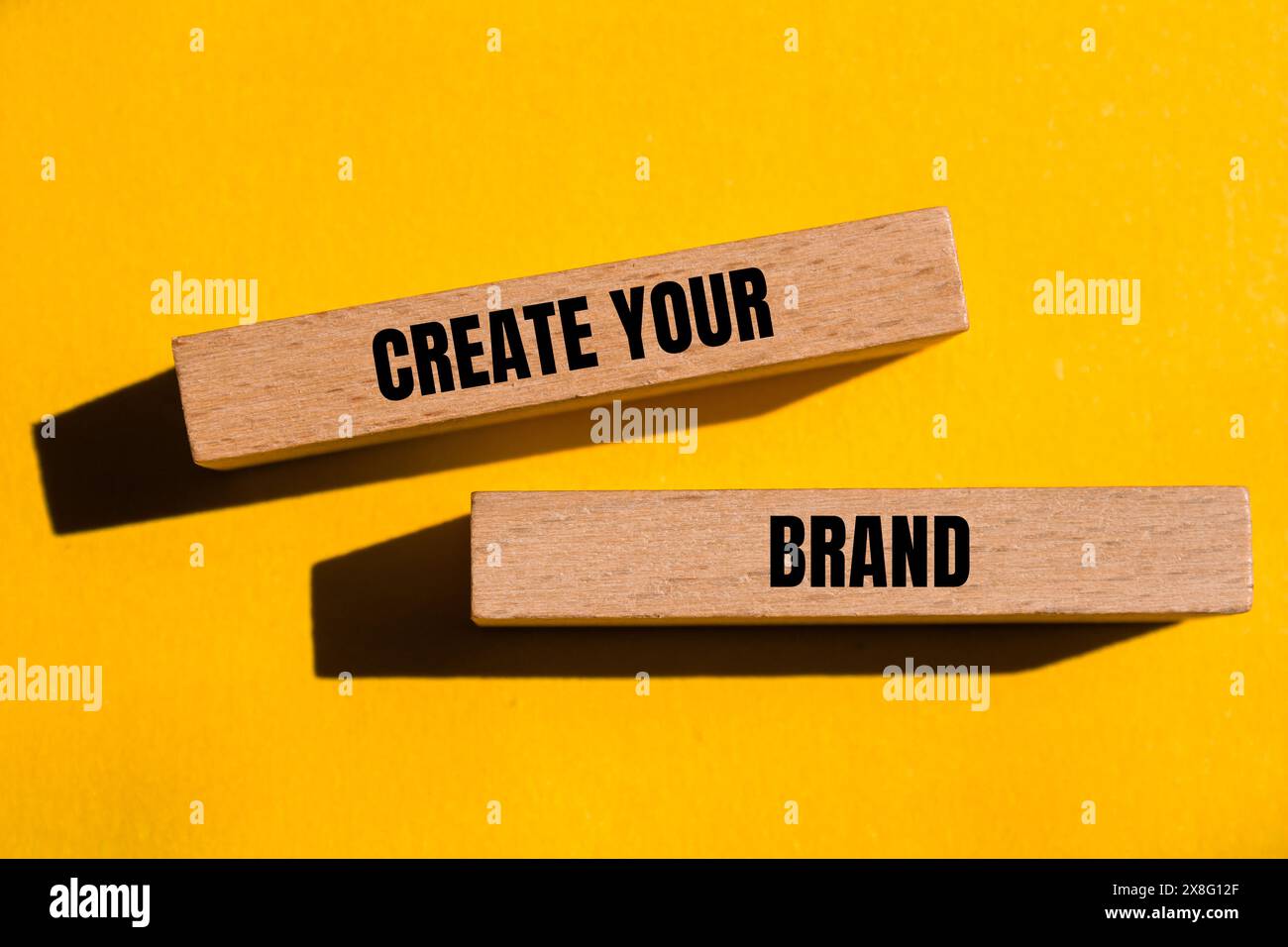 Create your brand words written on wooden blocks with yellow background ...