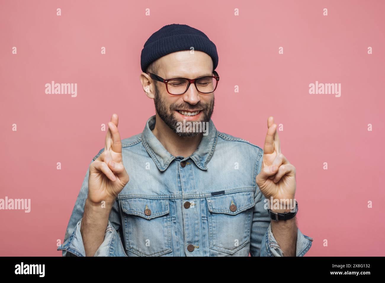Hopeful man crossing fingers for good luck, displaying wishful thinking ...