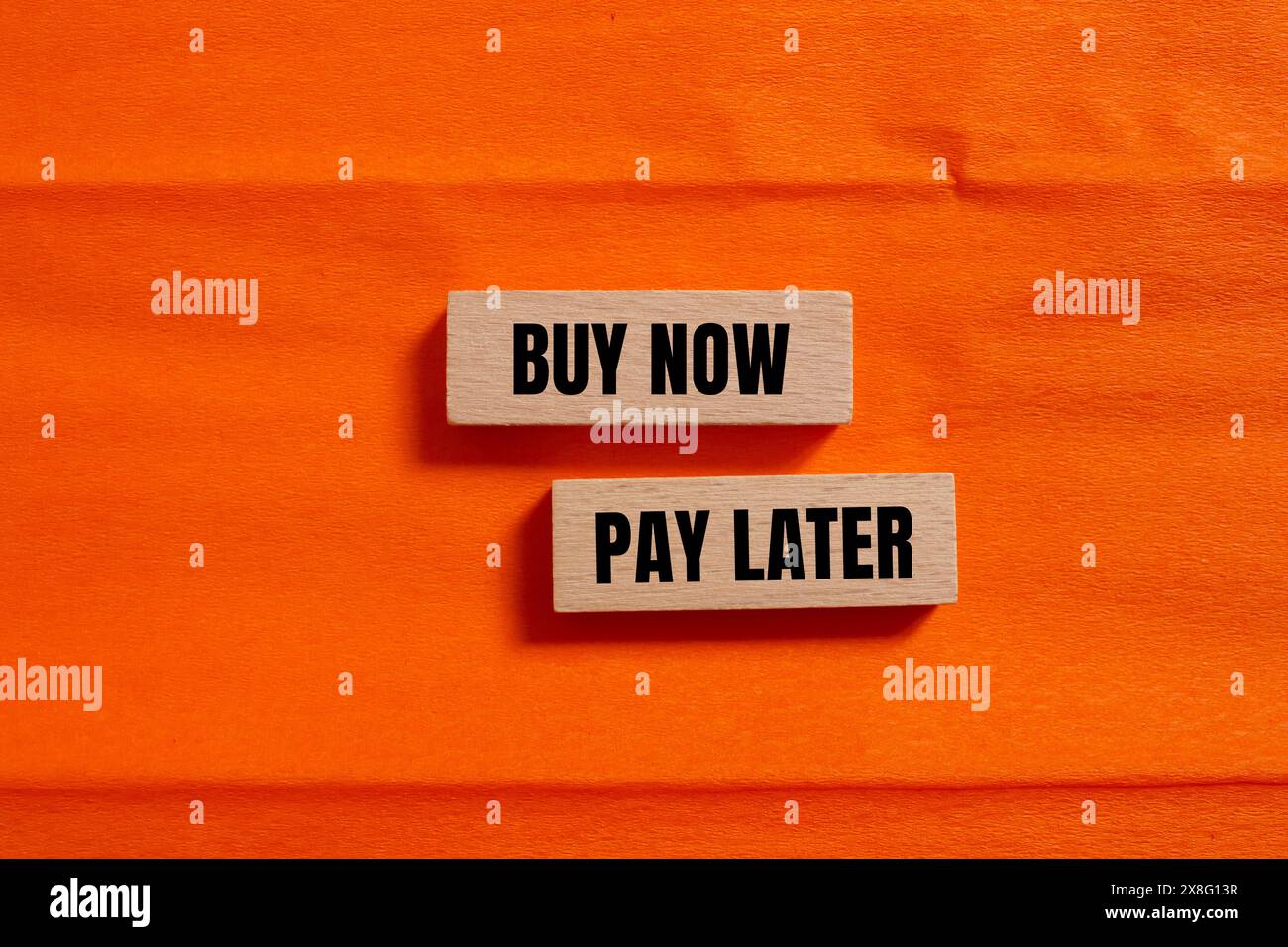 Buy now pay later words written on wooden blocks with orange background ...