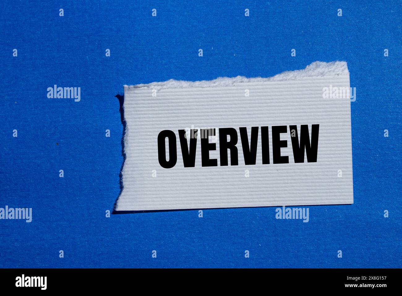 Overview word written on ripped white paper piece with blue background. Conceptual overview word ...