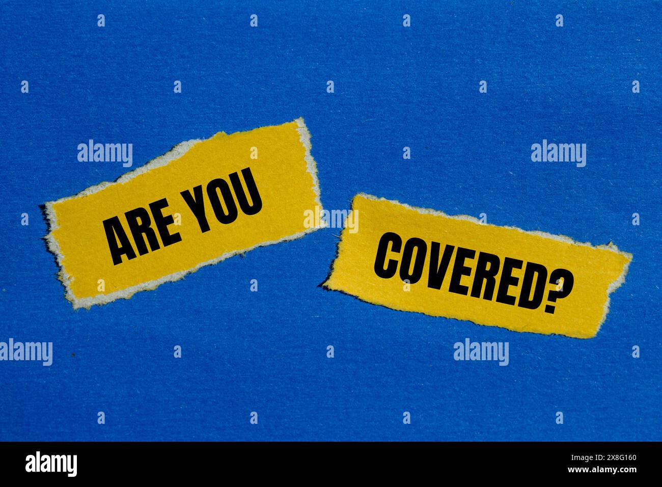 Are you covered ? words written on ripped yellow paper pieces with blue ...