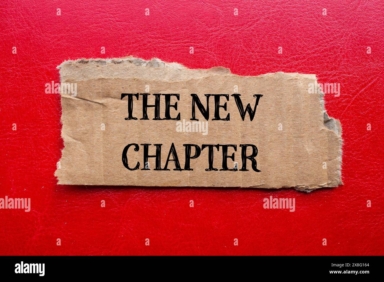 The new chapter words written on ripped cardboard paper piece with red ...