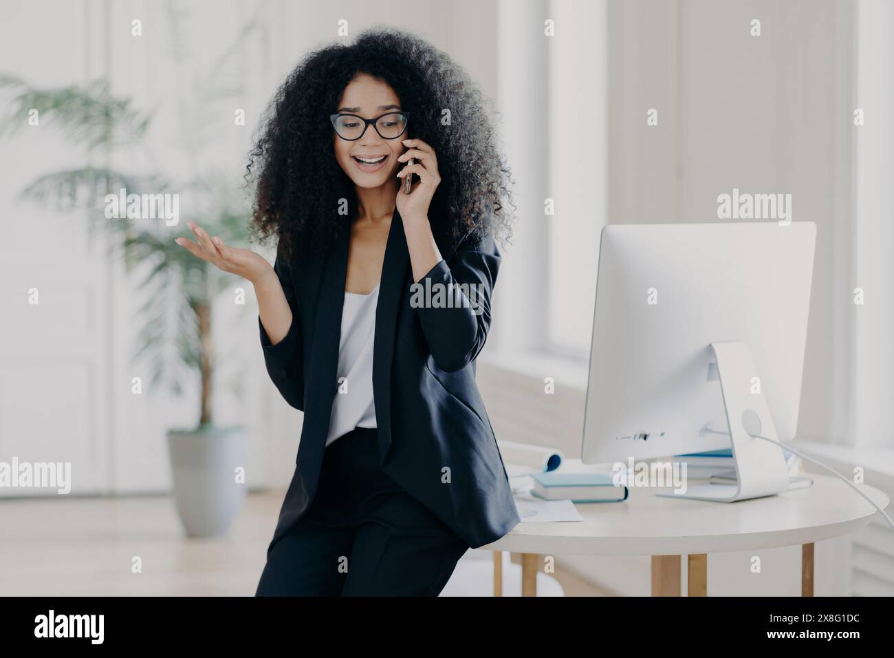 A businesswoman engaging in an animated phone call, her expressive hand ...