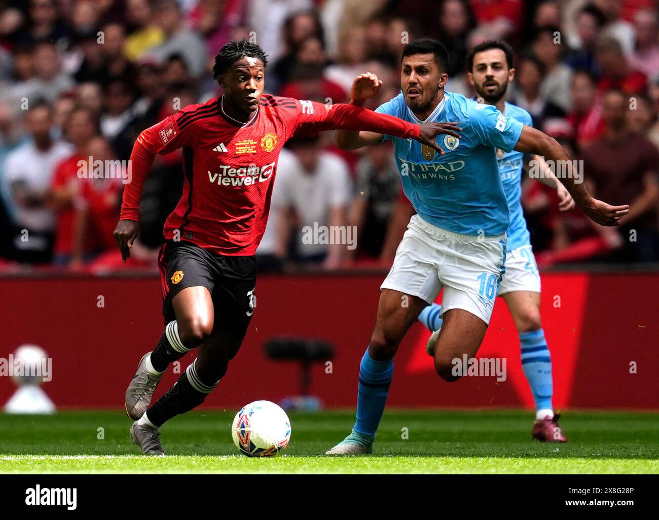 Manchester United's Kobbie Mainoo (left) and Manchester City's Rodri ...