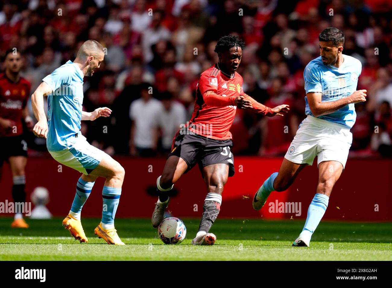 Manchester United's Kobbie Mainoo (left) and Manchester City's Rodri ...