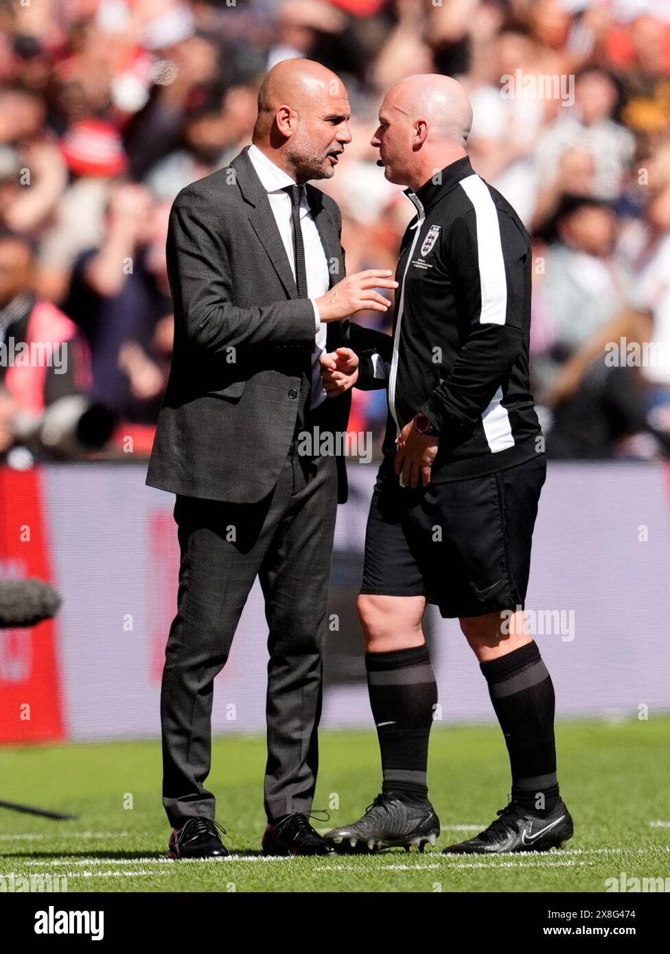 Manchester City manager Pep Guardiola speaks with fourth official Simon ...