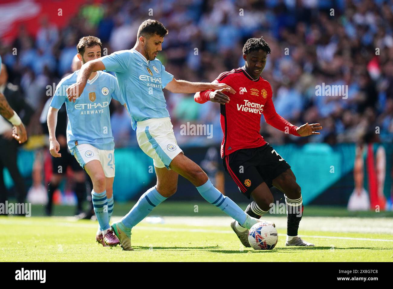 Manchester City's Rodri (left) and Manchester United's Kobbie Mainoo ...