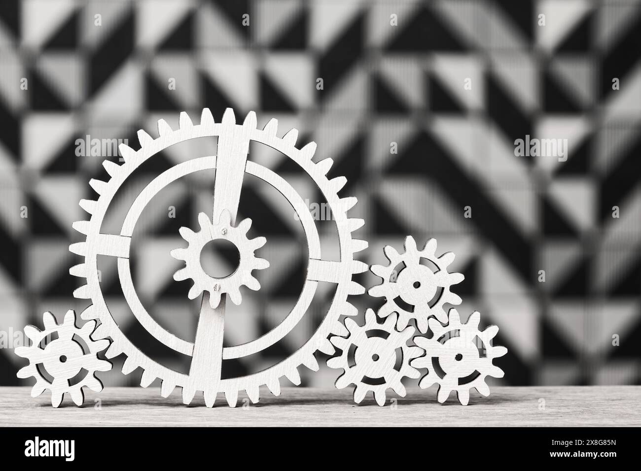 Wooden cog wheel gears system standing on the table. Engineering theme ...