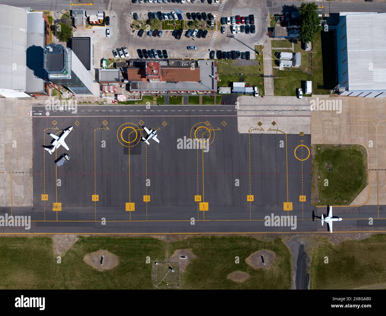 Aerial view of an airport with planes parked on the runway next to the ...