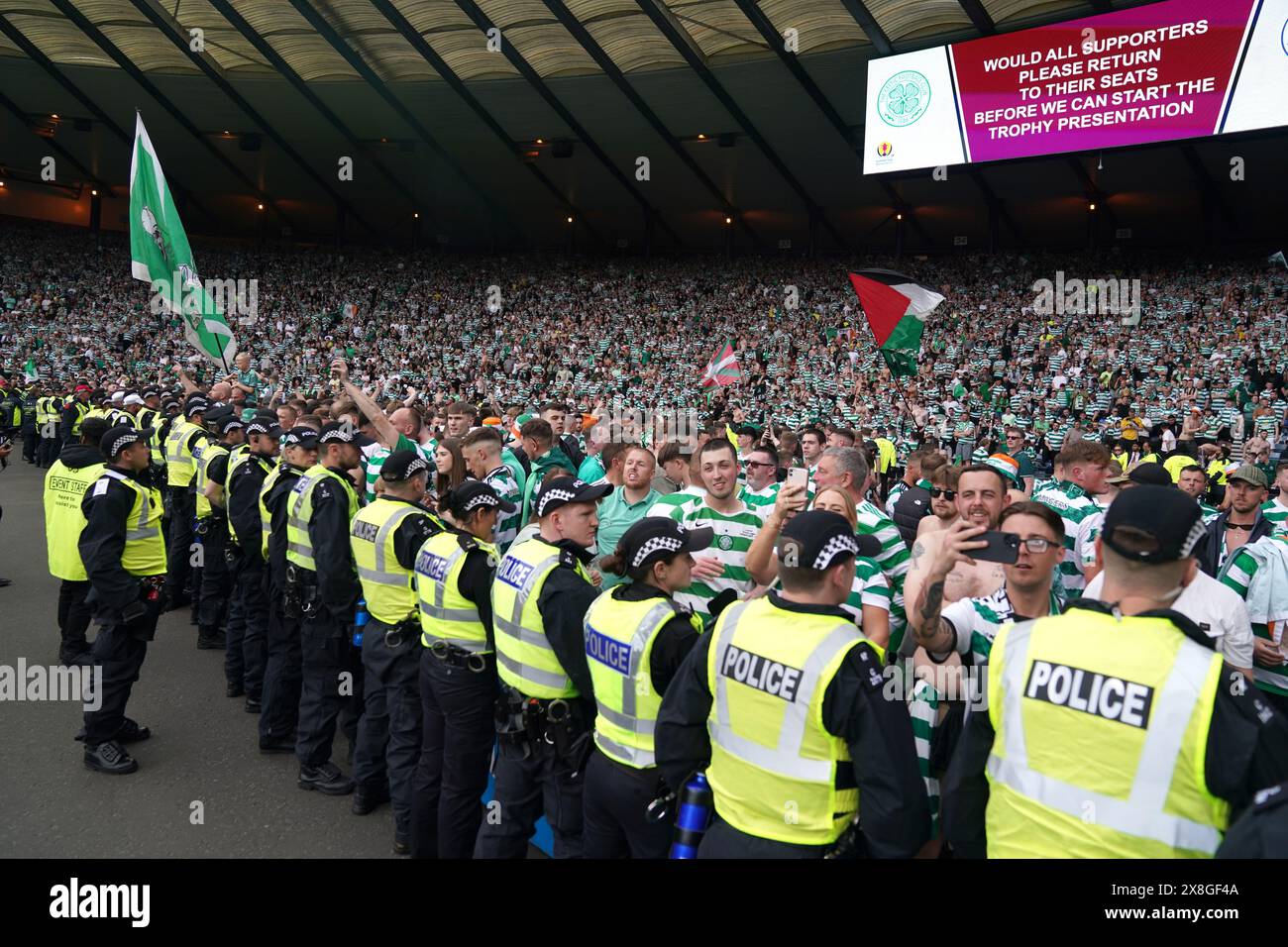 Celtic fans attempt to invade the pitch but are kept behind a police ...